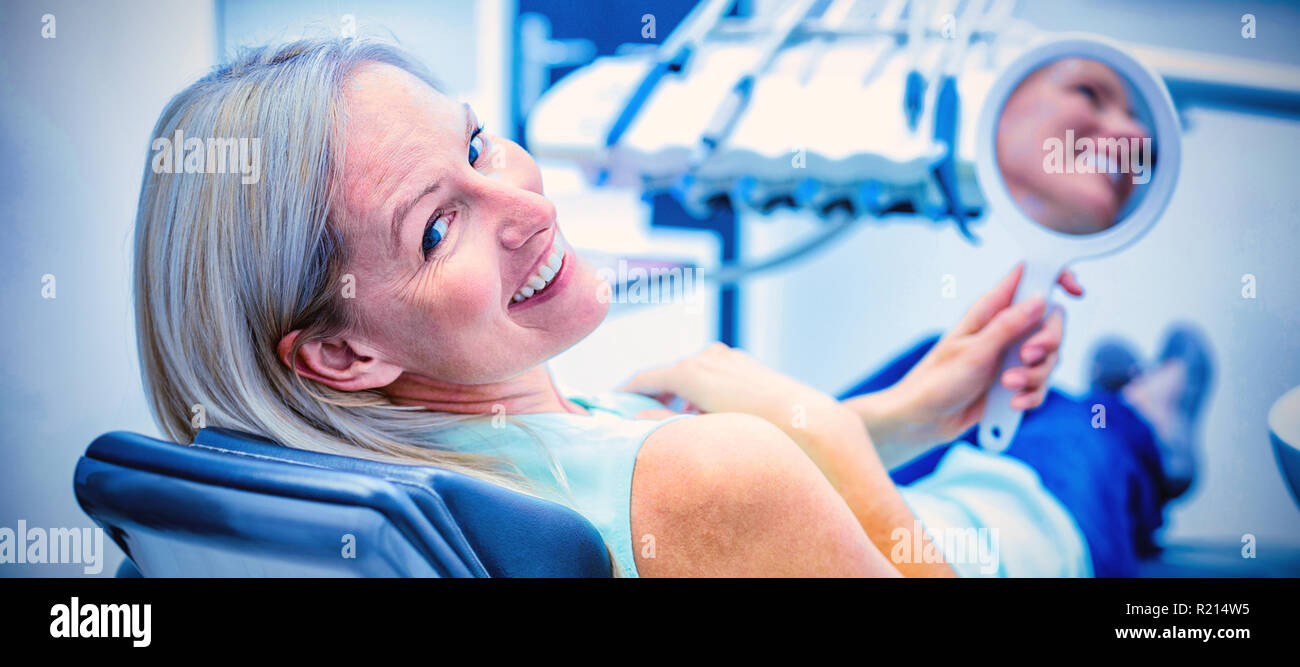 Female patient smiling while holding mirror Stock Photo - Alamy