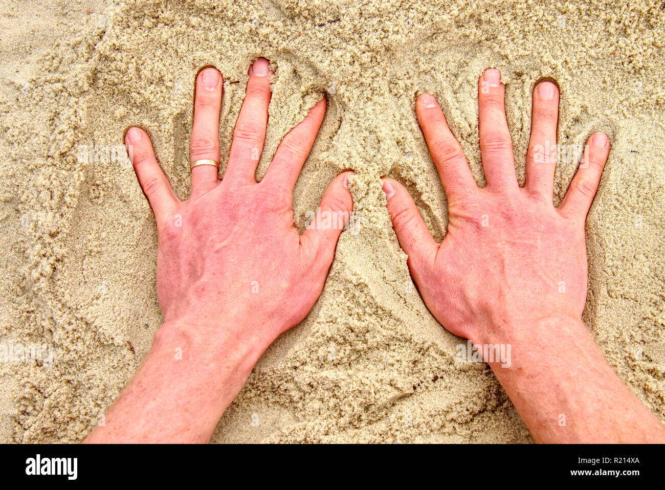 Adult hand is drawing a finger on the sand symbol. Sandy beach Stock ...