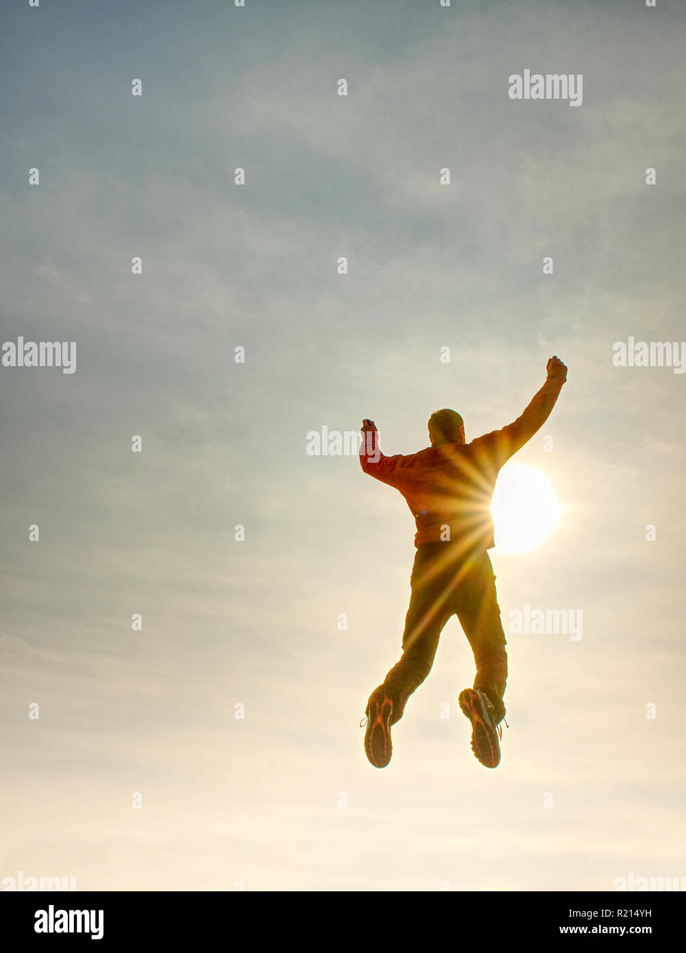 Flying man. Silhouette of jumping man and sunset sky. Sun flare Stock ...