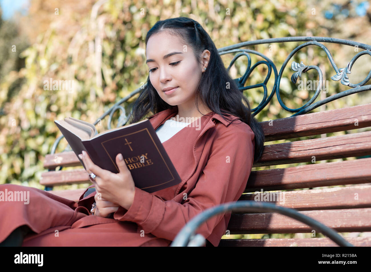 Relaxed Asian girl reading Holy Bible on air Stock Photo - Alamy