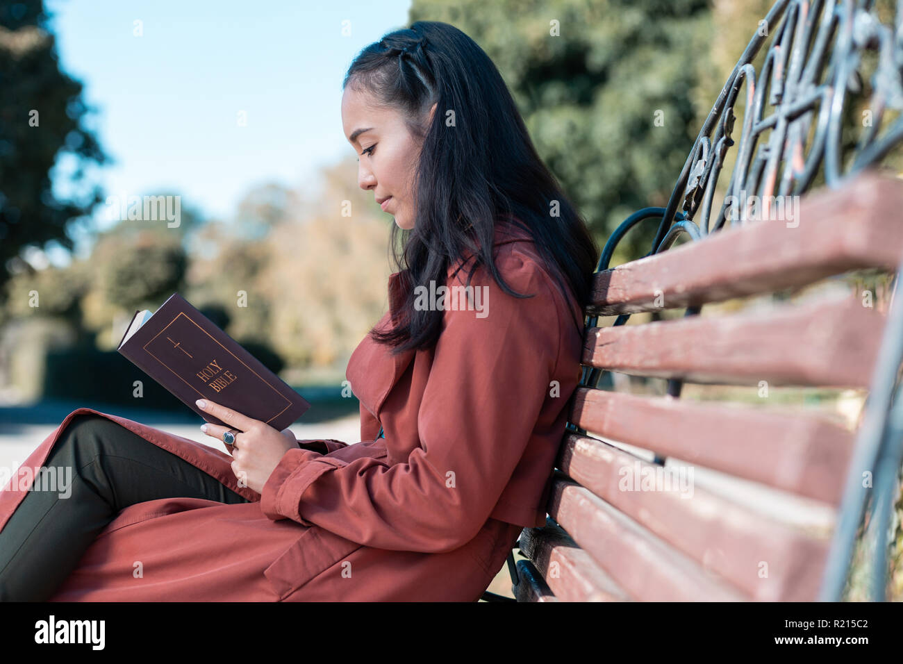 Attentive brunette girl sitting in semi position Stock Photo - Alamy