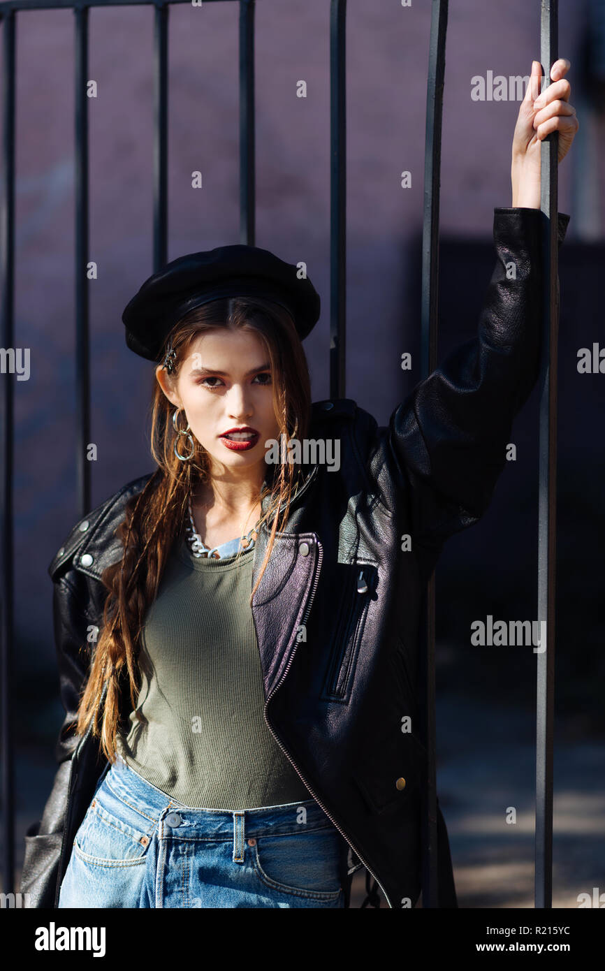 Young girl wearing khaki shirt and black leather jacket working as ...