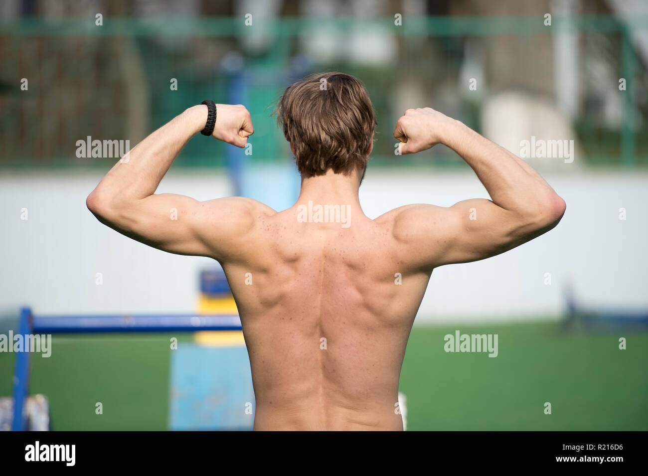 Proud of his shape. Man athlete training outdoor shows his muscular ...