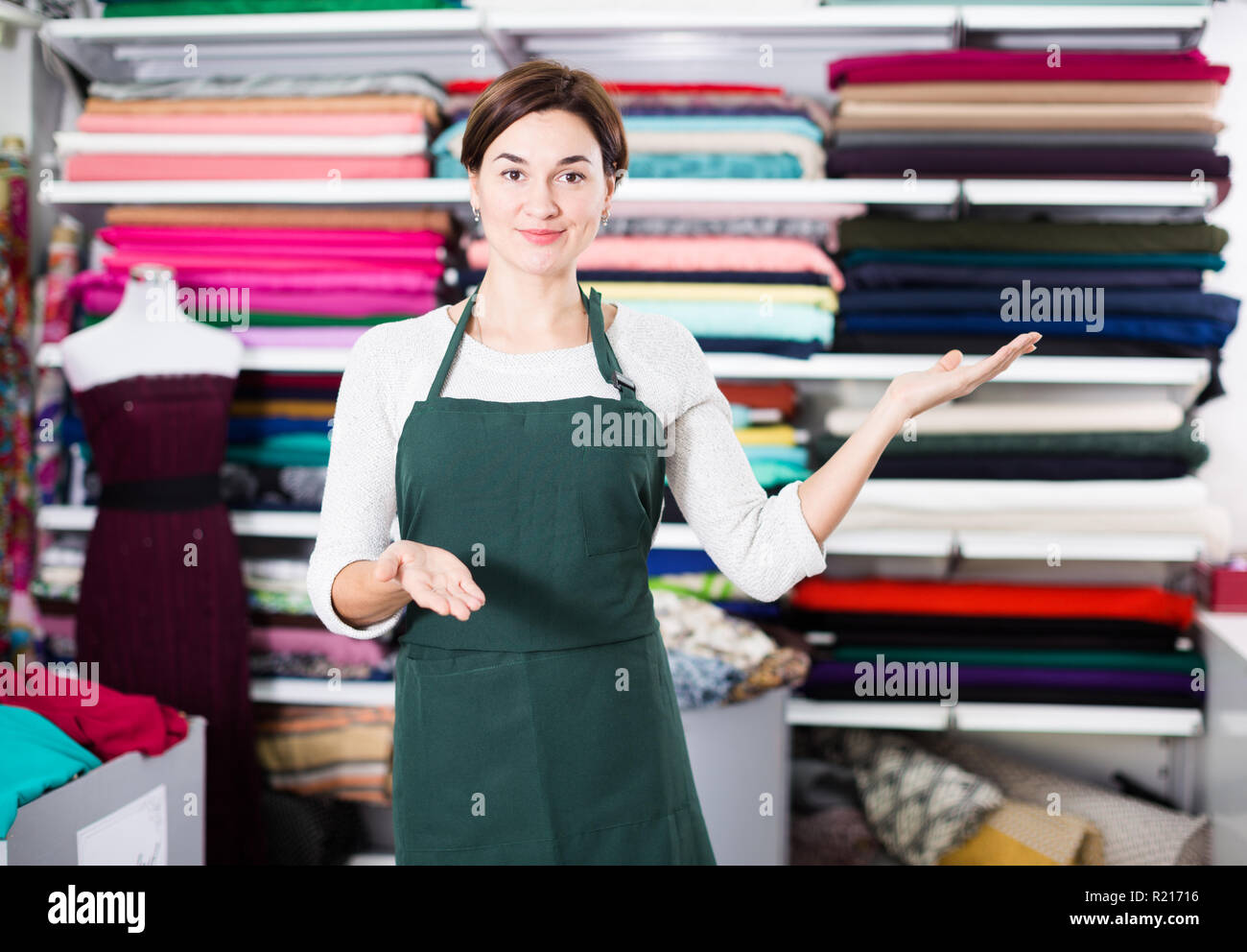 Female shop assistant demonstrating assortment at drapery shop Stock ...