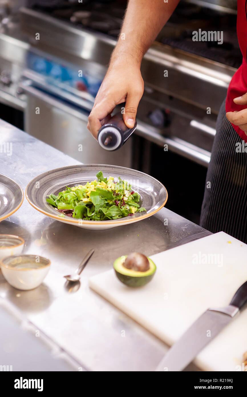 Chef seasoning delicious salade in his restaurant kitchen Stock Photo ...