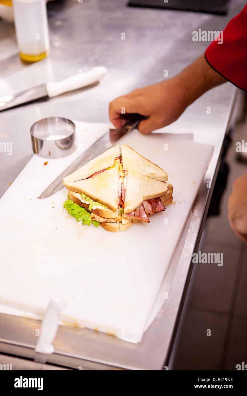 Chef making sandwich in rustic style with bacon and fresh vegetables ...