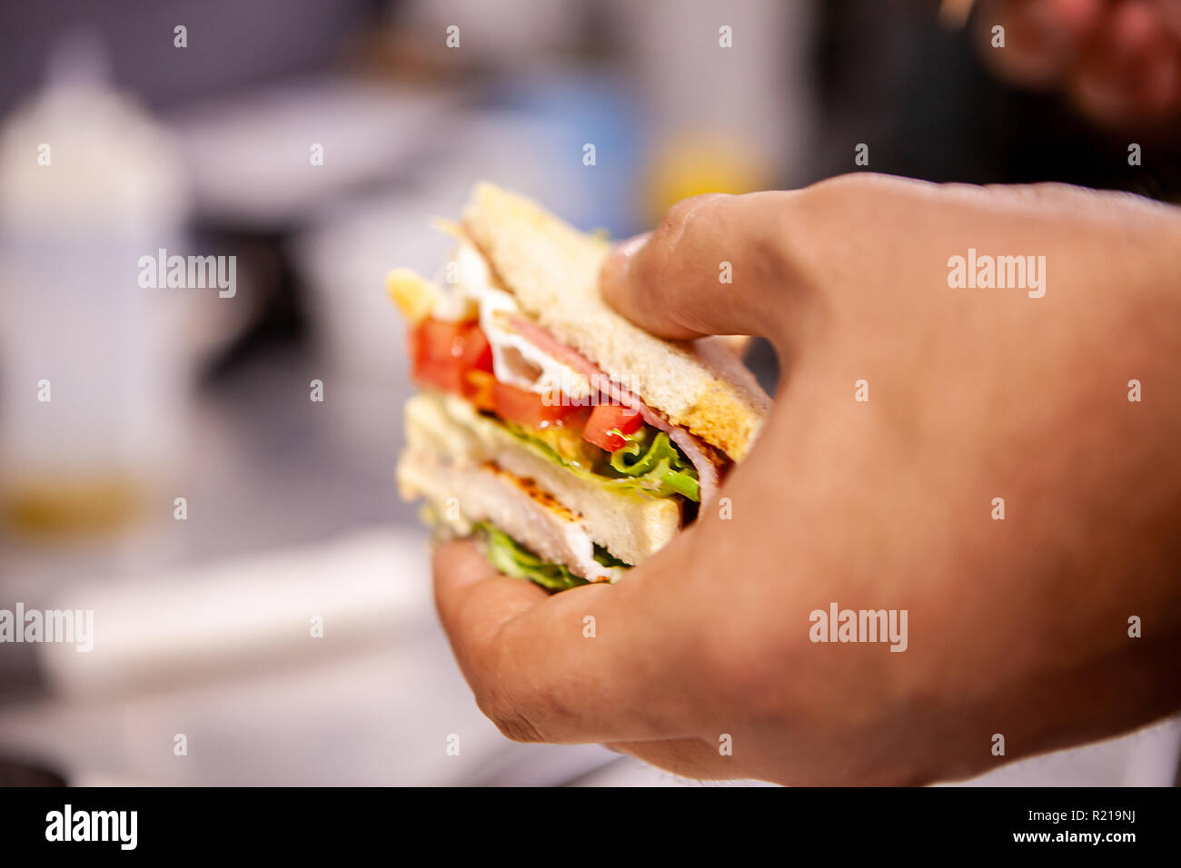 Chef making sandwich in rustic style with bacon and fresh vegetables ...