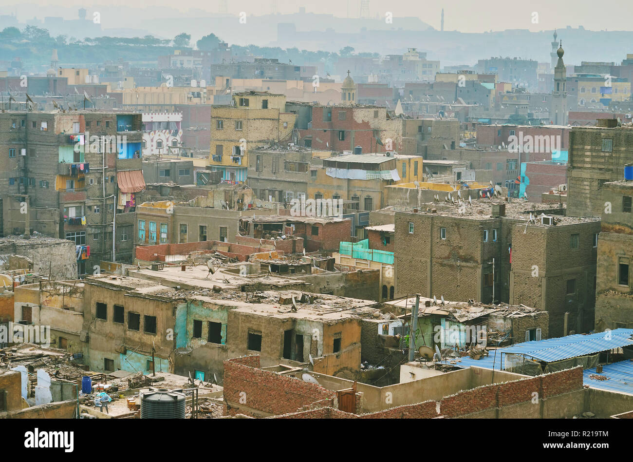 The morning winter fog covers the shabby buildings and slums of Islamic ...
