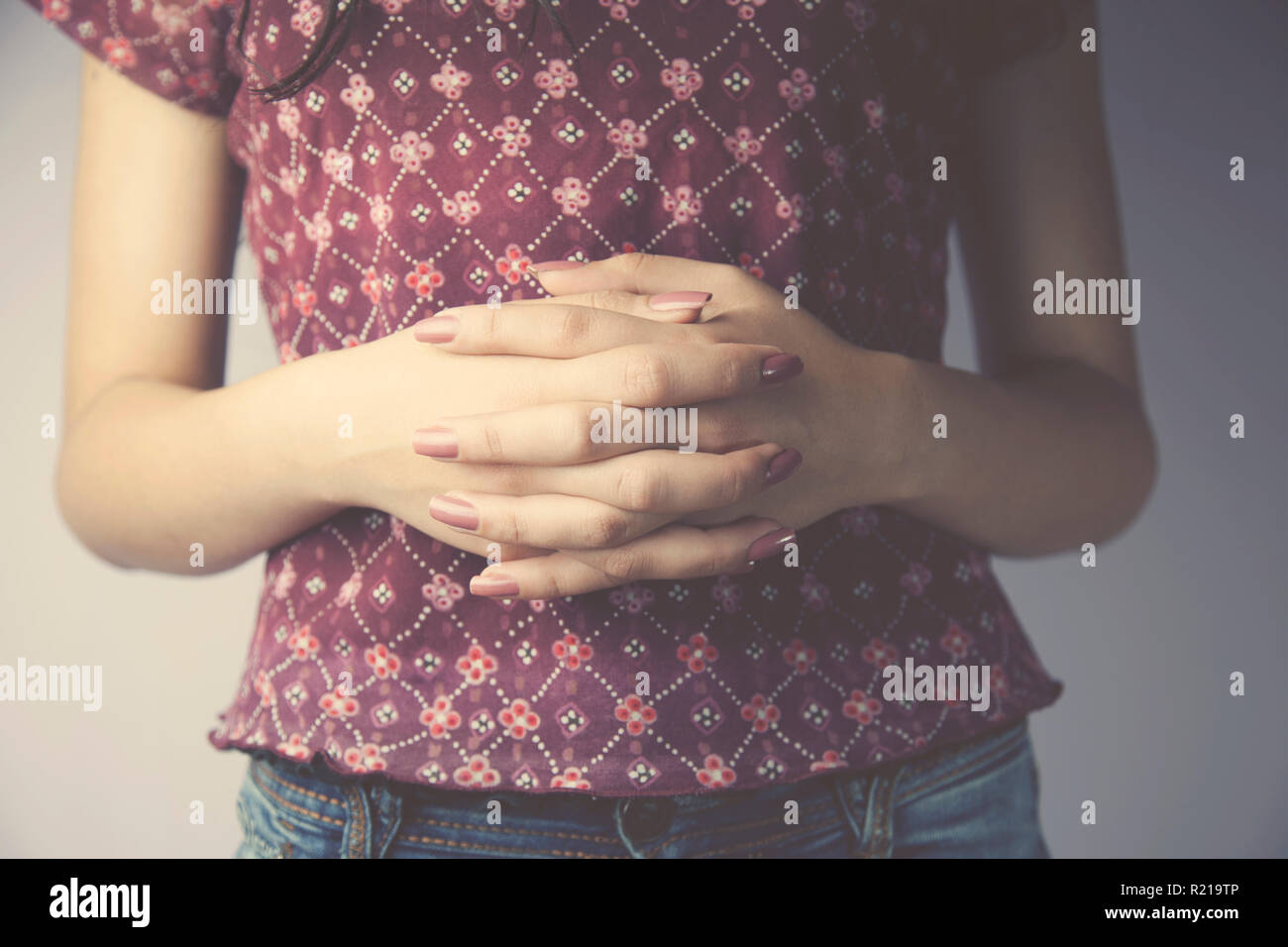 Young woman hands folded in front Stock Photo - Alamy