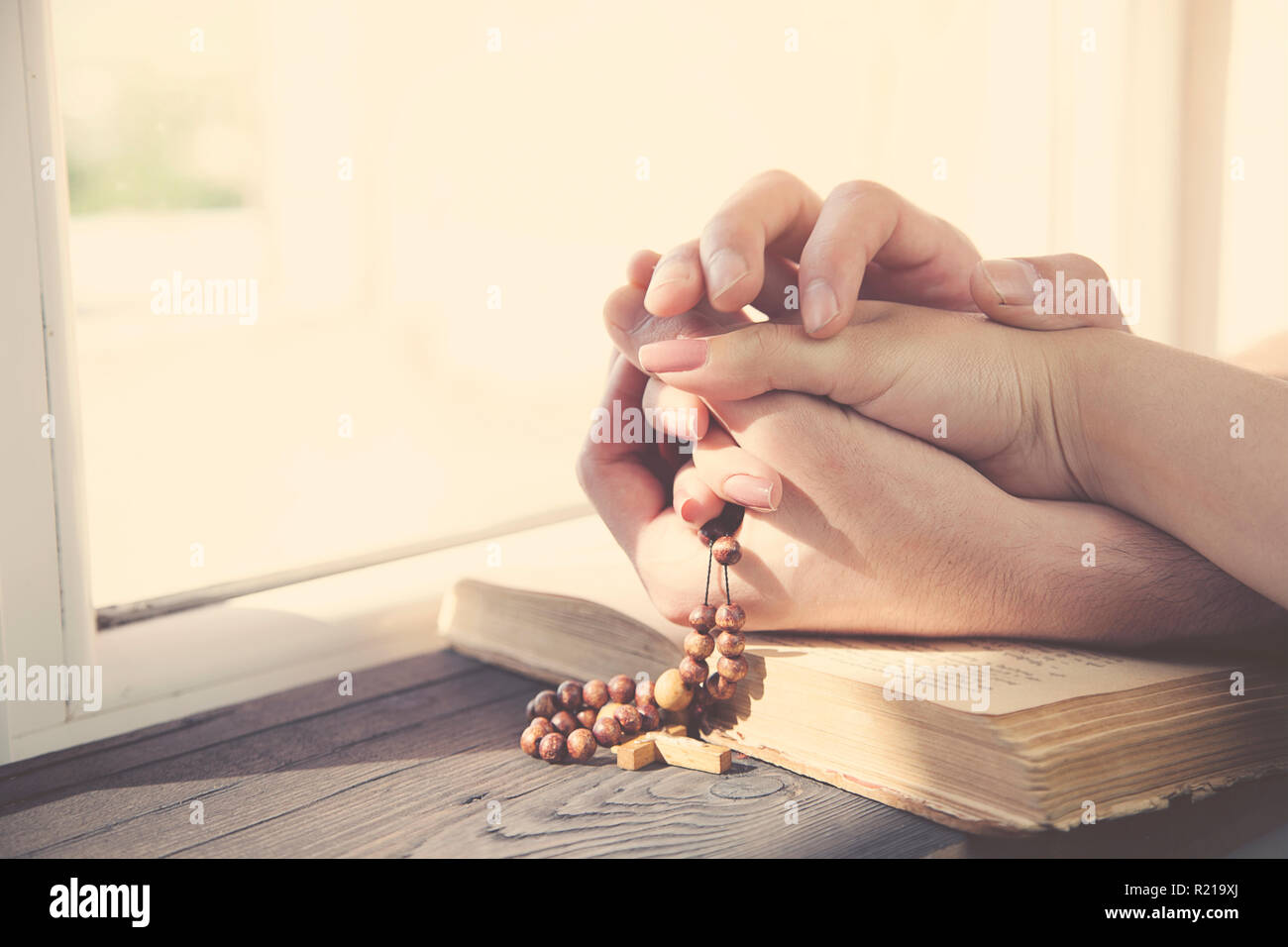 cross on the couple hands on wooden background Stock Photo - Alamy