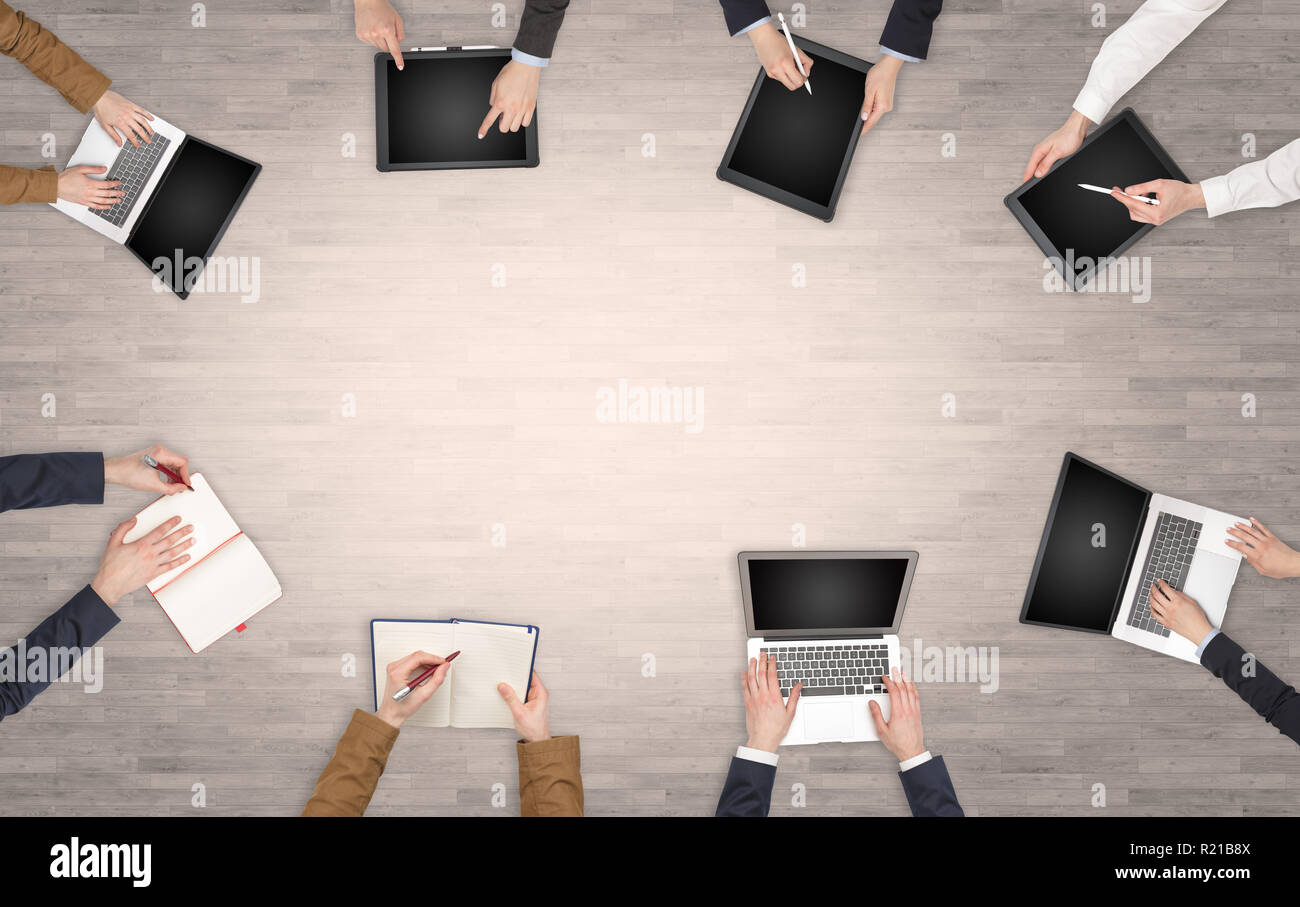 Group of people with devices in hands having desk discussion and making ...