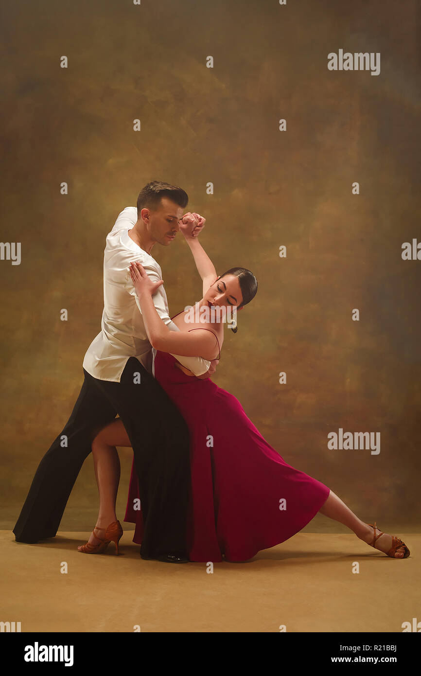The young dance ballroom couple in gold dress dancing in sensual pose ...