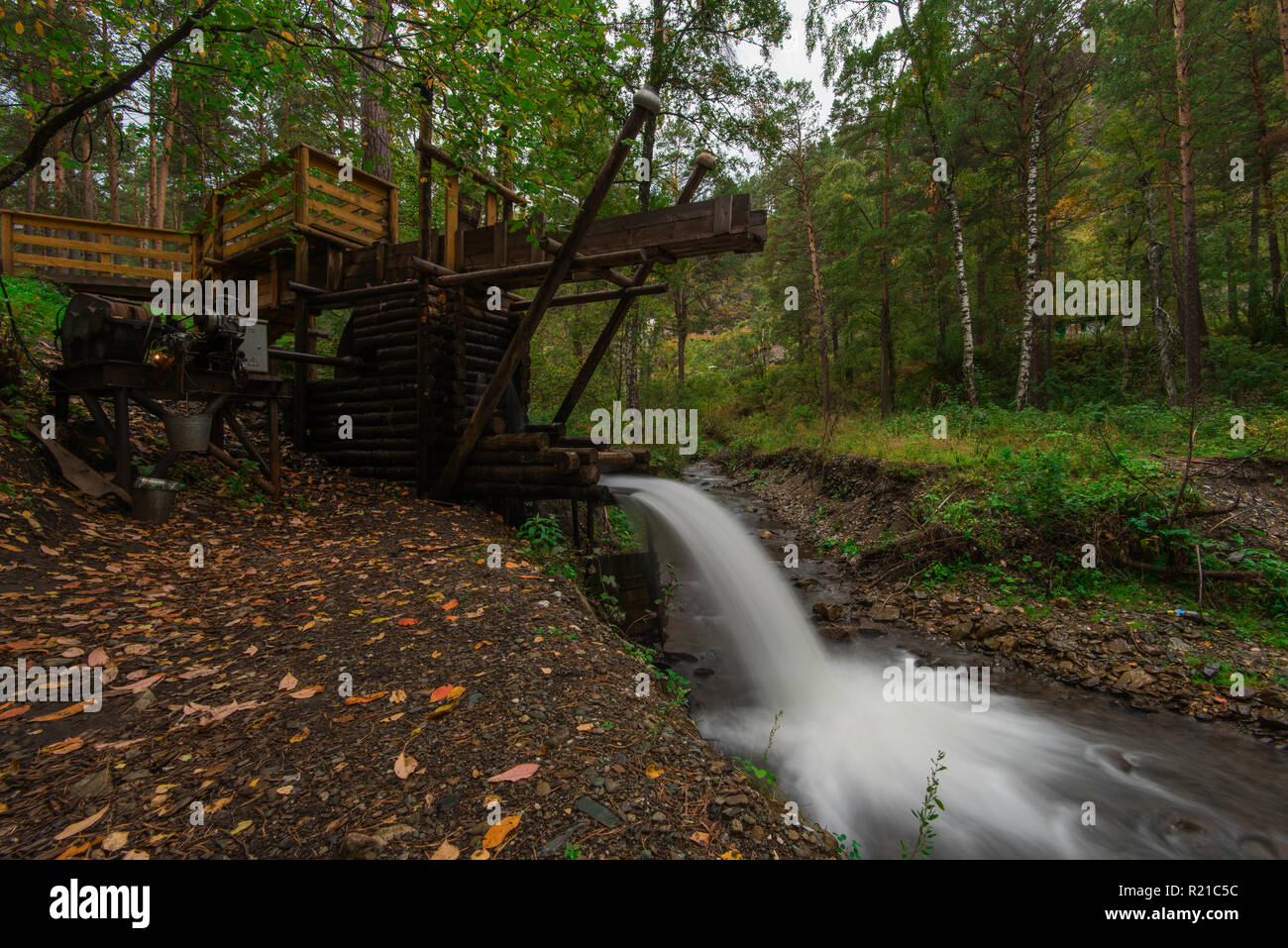 Rustic watermill with wheel being turned by force of falling water from ...