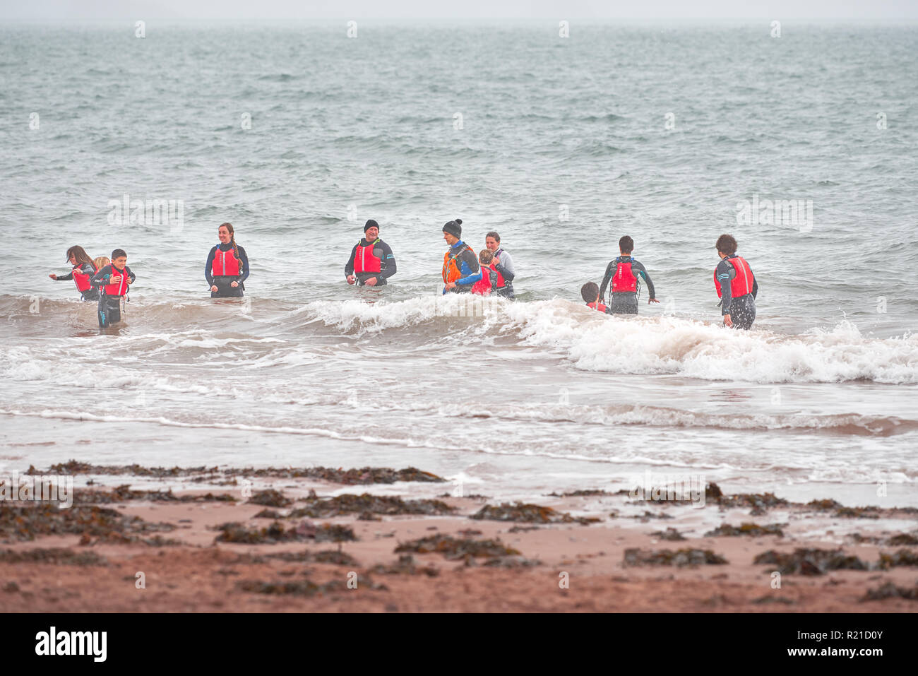 Neoprene clad dippers with buoyancy aids paddle in the English Channel ...