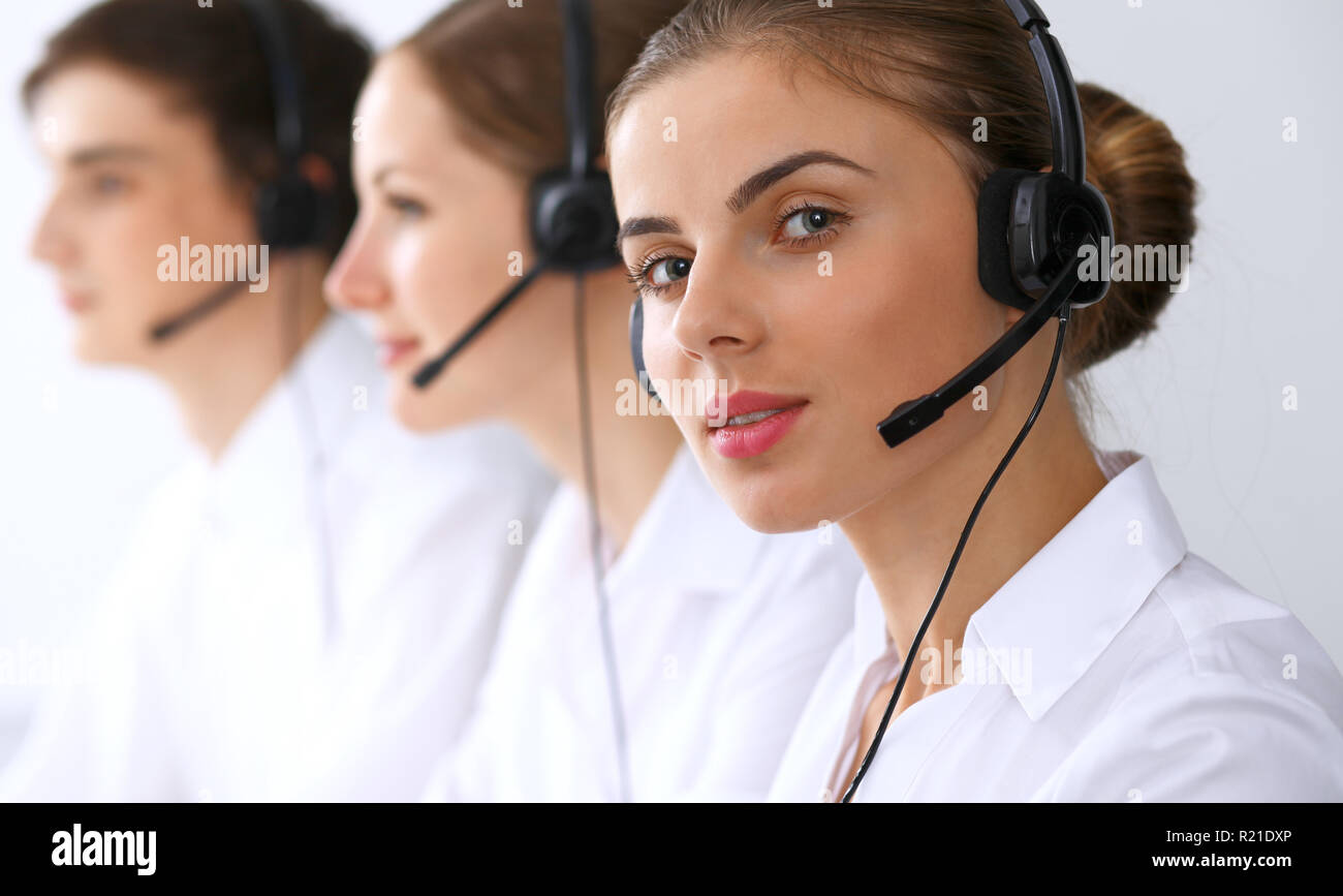 Call center. Focus on beautiful woman in headset Stock Photo - Alamy