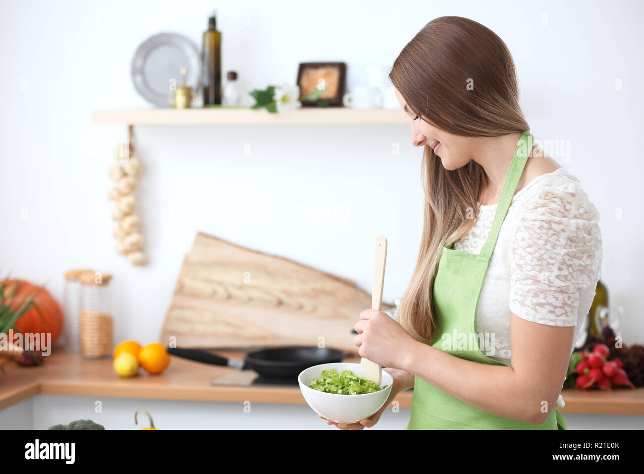 Young woman cooking in the kitchen. Housewife slicing fresh salad Stock ...