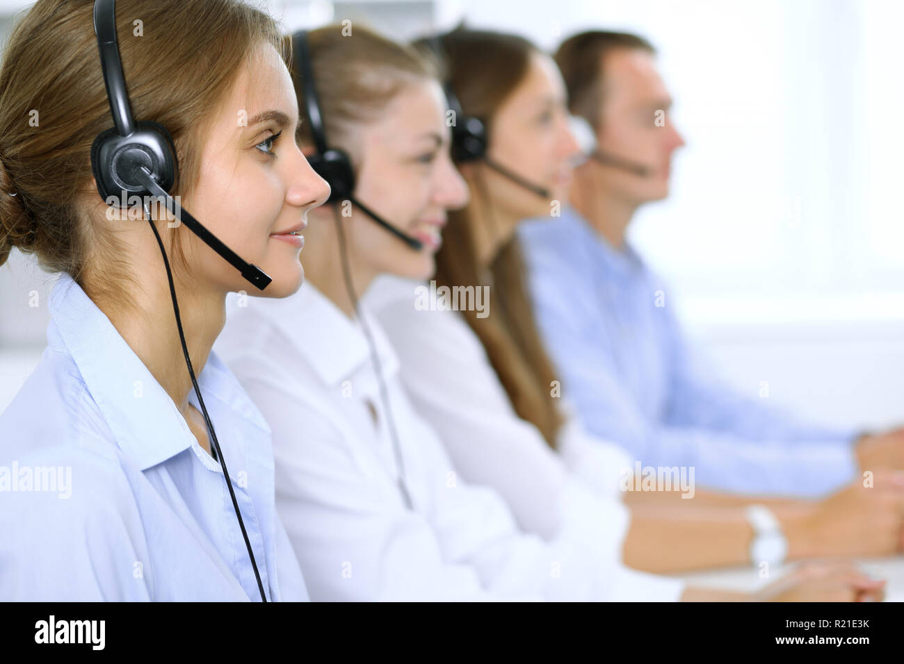 Call center operator in headset while consulting client. Telemarketing ...