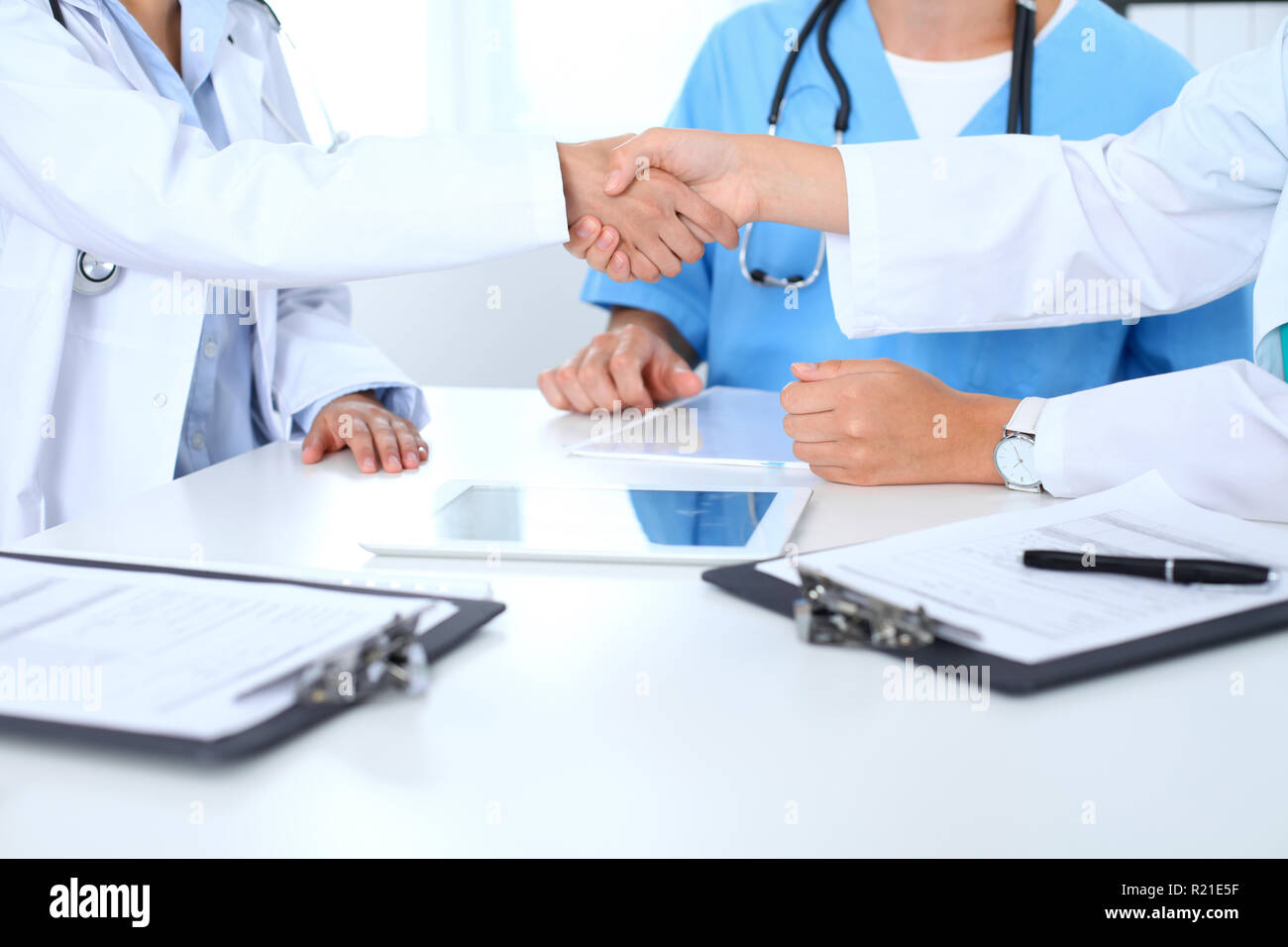 Group doctors joining hands hi-res stock photography and images - Alamy