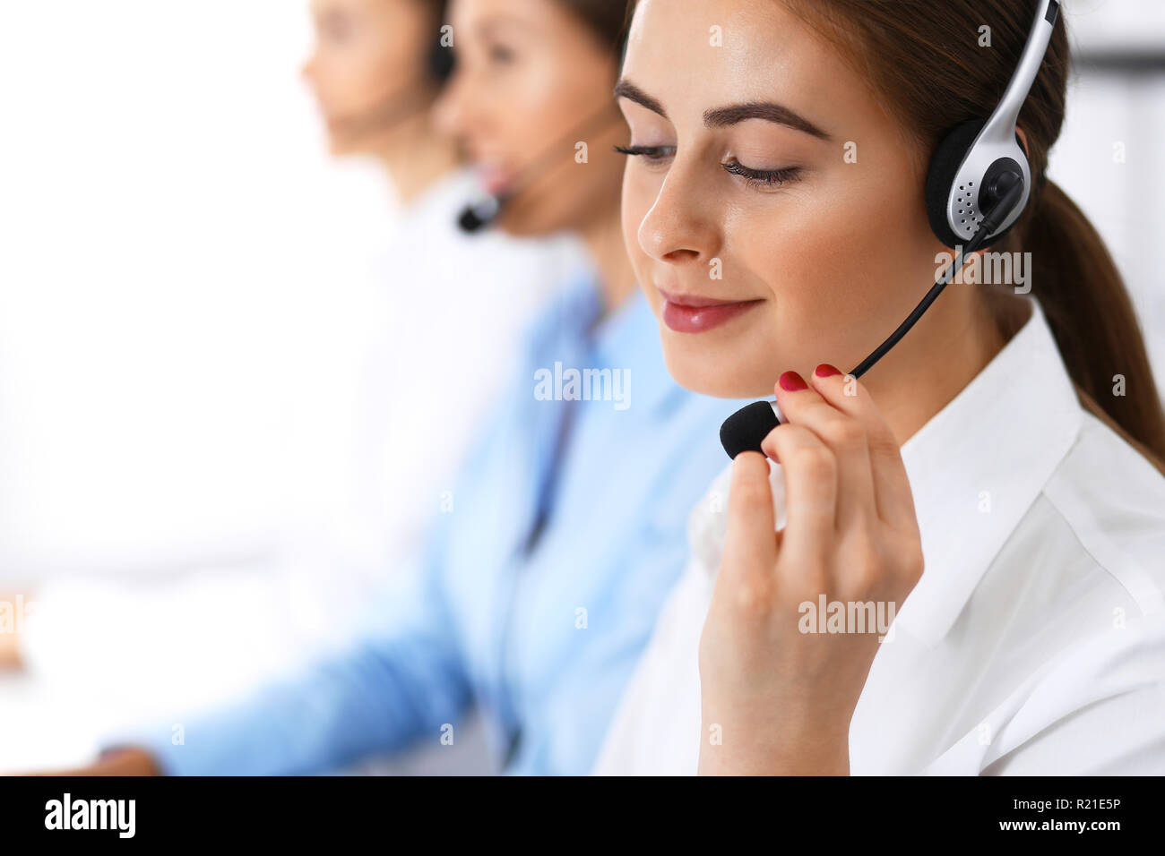 Call center. Group of operators at work. Focus at beautiful business woman in headset Stock ...