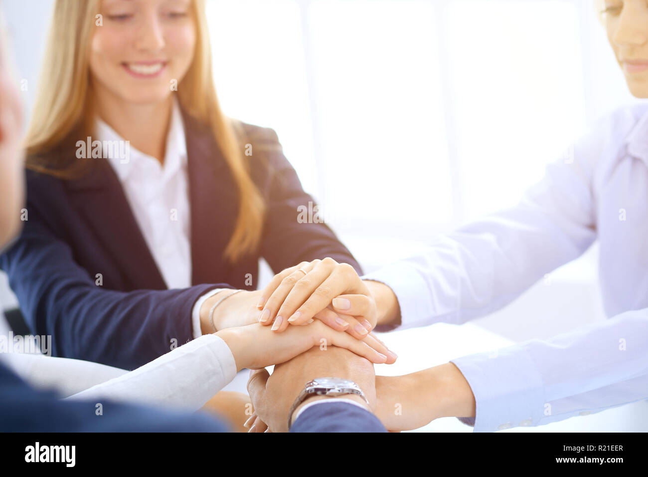 Business team showing unity with their hands together. Group of people joining hands and ...