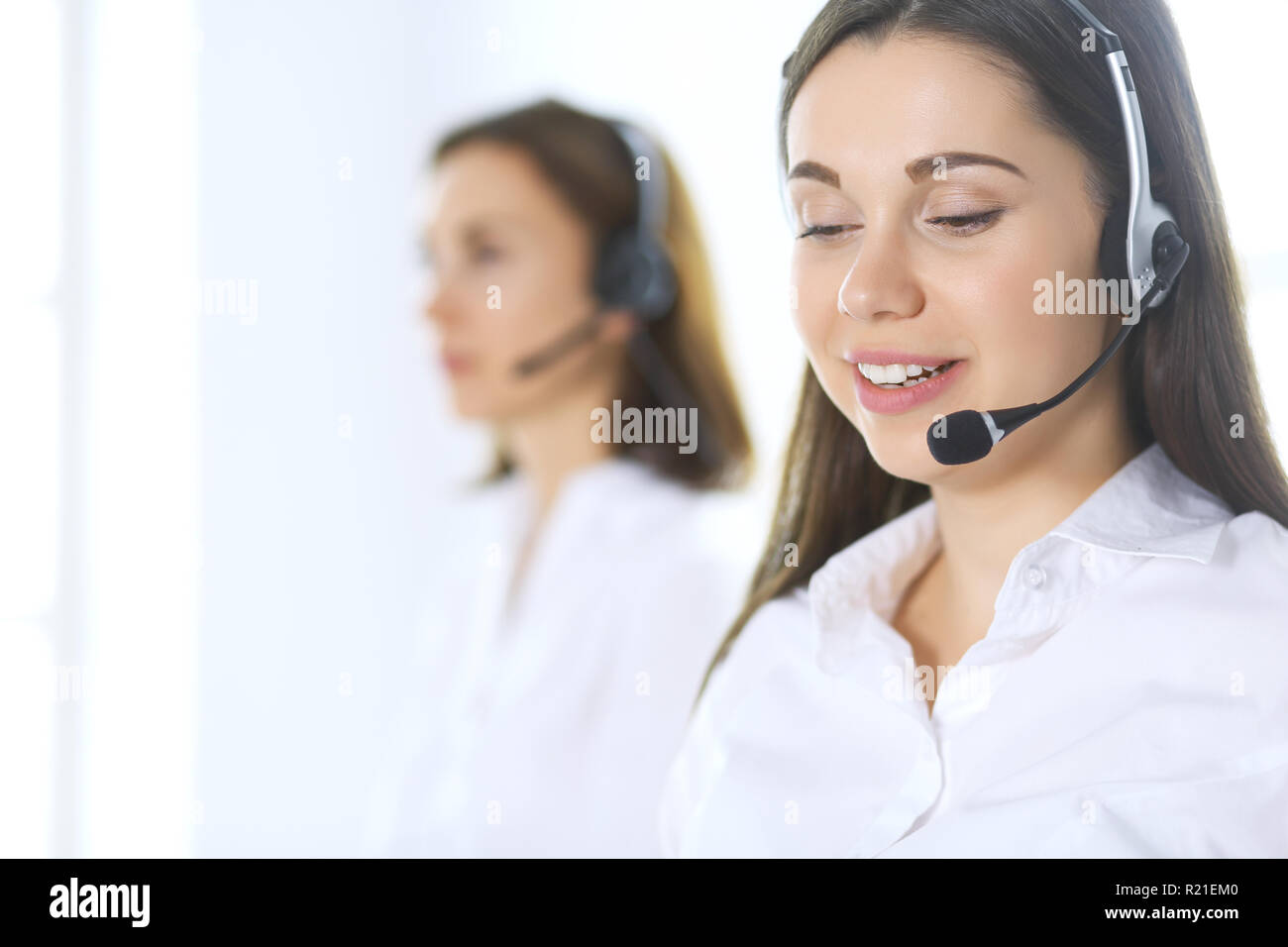 Group of call center operators at work. Focus on beautiful business woman in headset Stock Photo ...