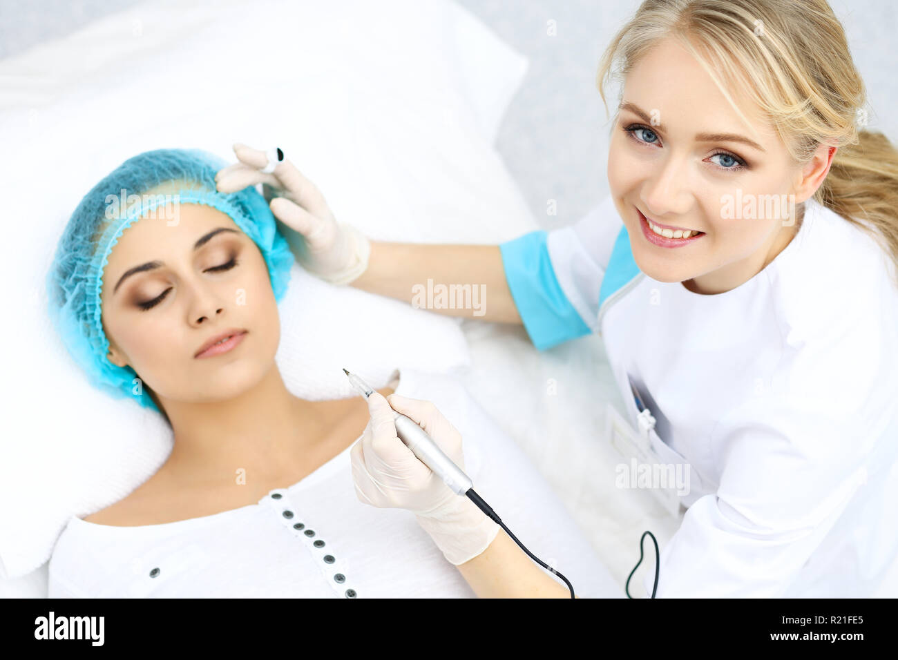 Professional beautician doing eyebrow tattoo at woman face. Permanent ...