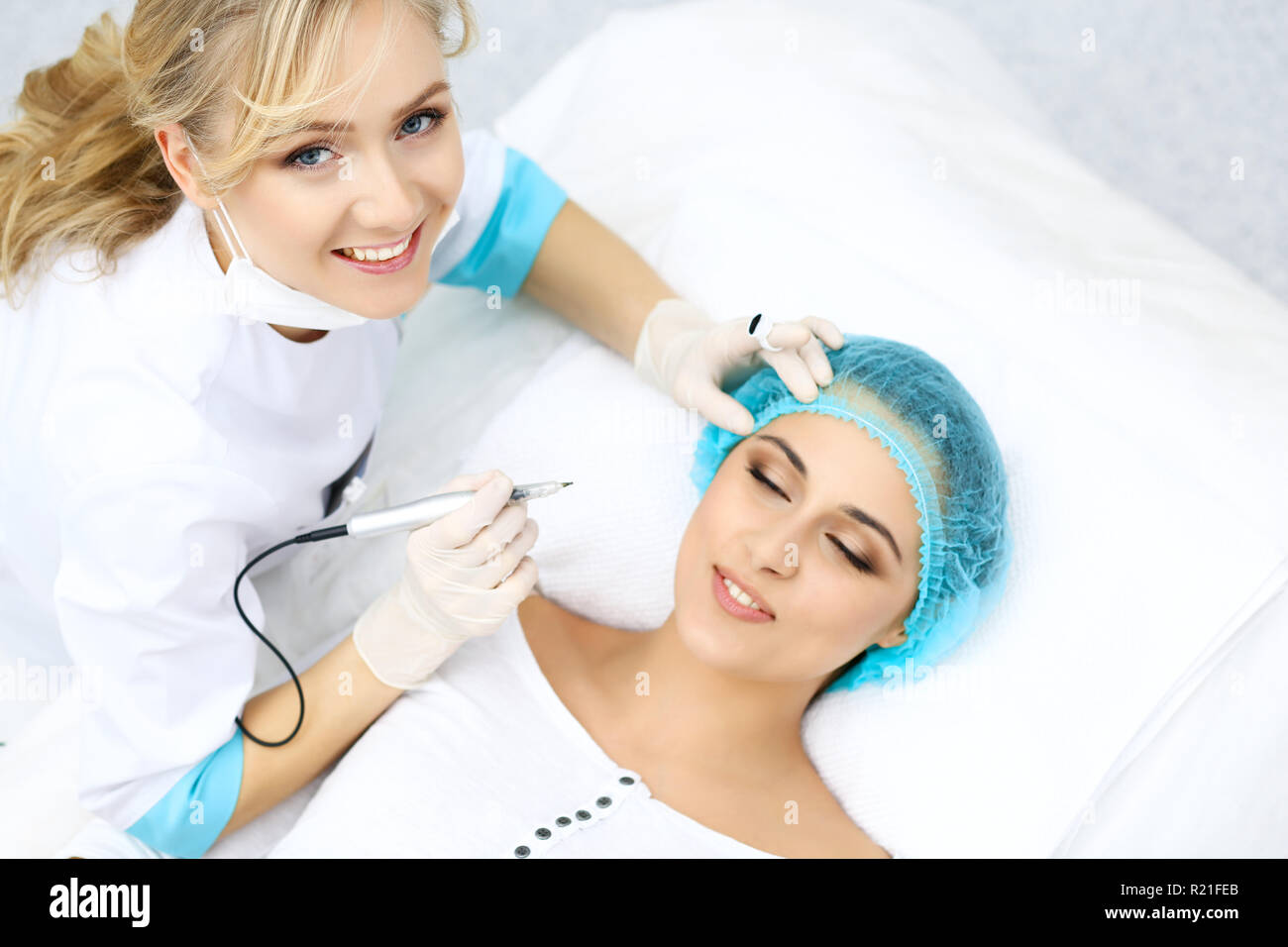 Professional beautician doing eyebrow tattoo at woman face. Permanent ...