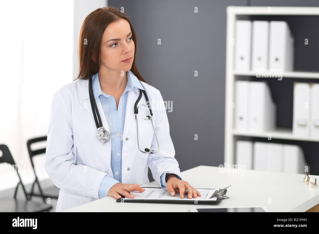 Doctor woman at work. Portrait of female physician filling up medical ...