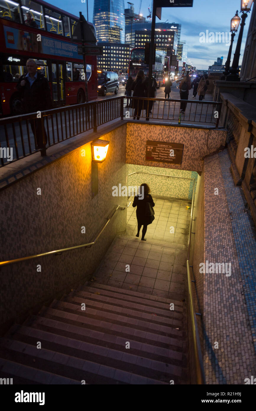 With the Shard in the background, a lady pedestrian descends steps into ...