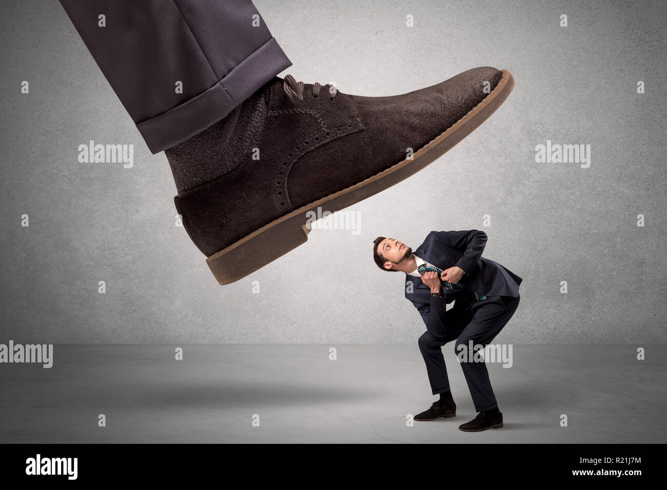 Employee is afraid of the big boss foot, which is stepping down him ...