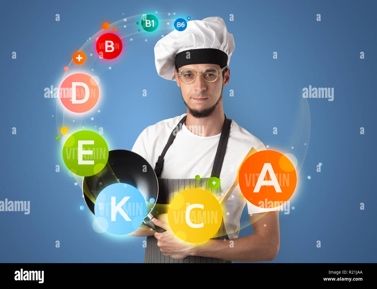 Handsome cook with kitchen instruments and vitamin concept Stock Photo ...
