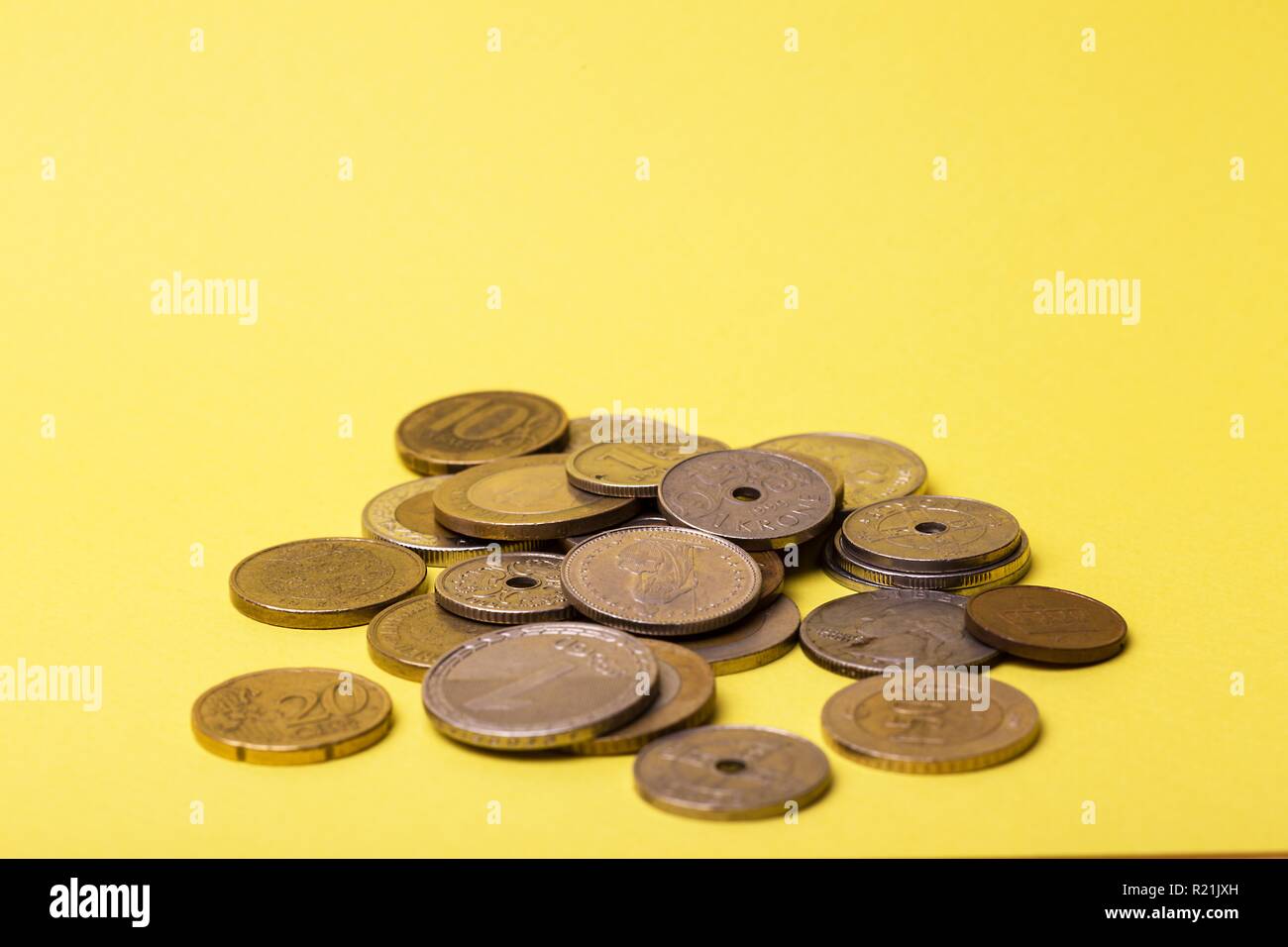 coins are scattered on a yellow background Stock Photo - Alamy