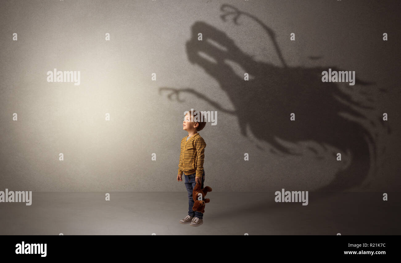 Scary ghost shadow in a dark empty room with a cute blond child Stock ...