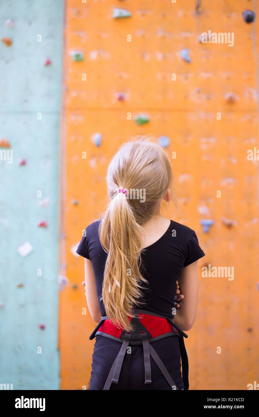 bouldering, little girl is standing and looking at the wall for ...