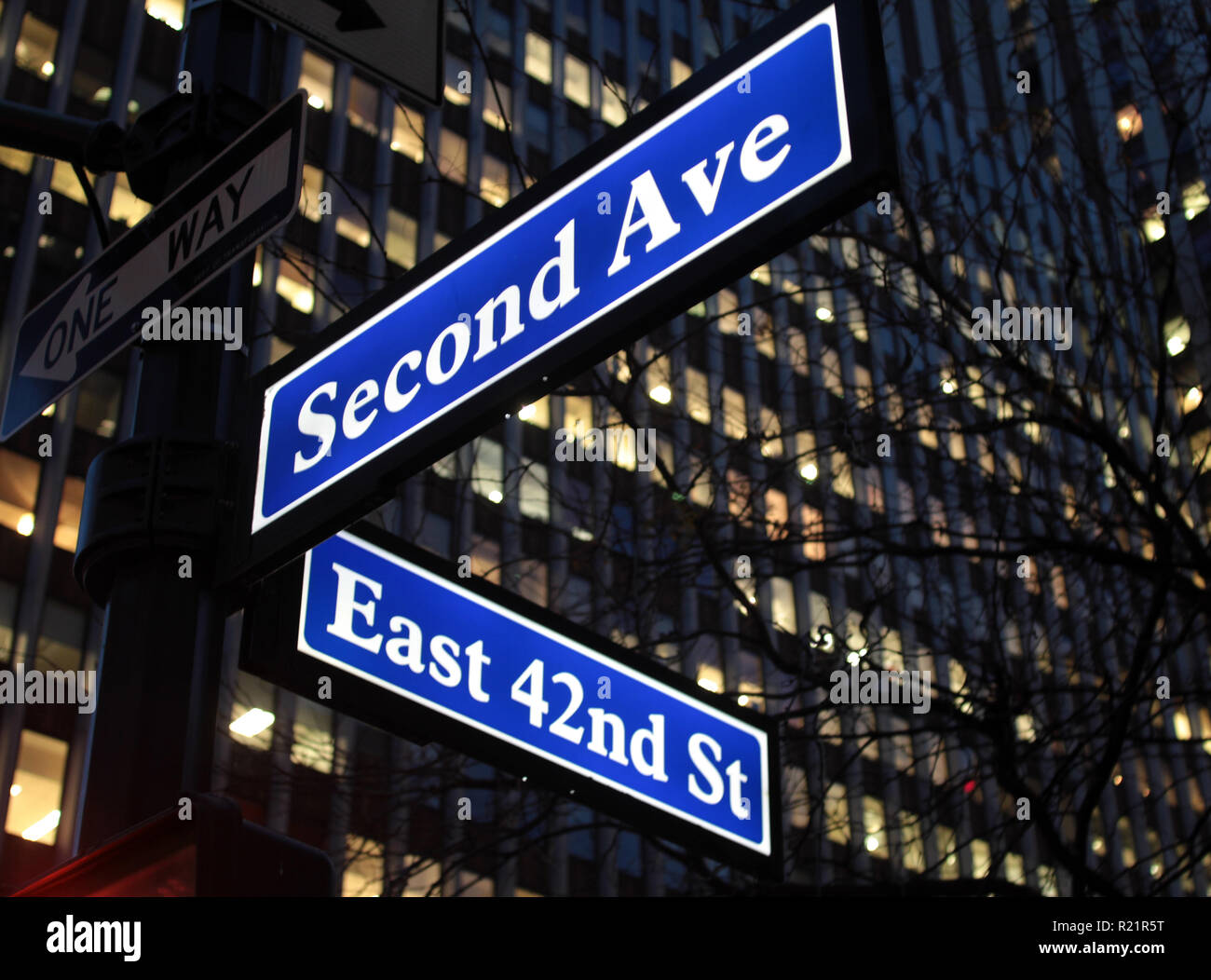 Two street signs, illuminated at night, points the way to Second Ave ...