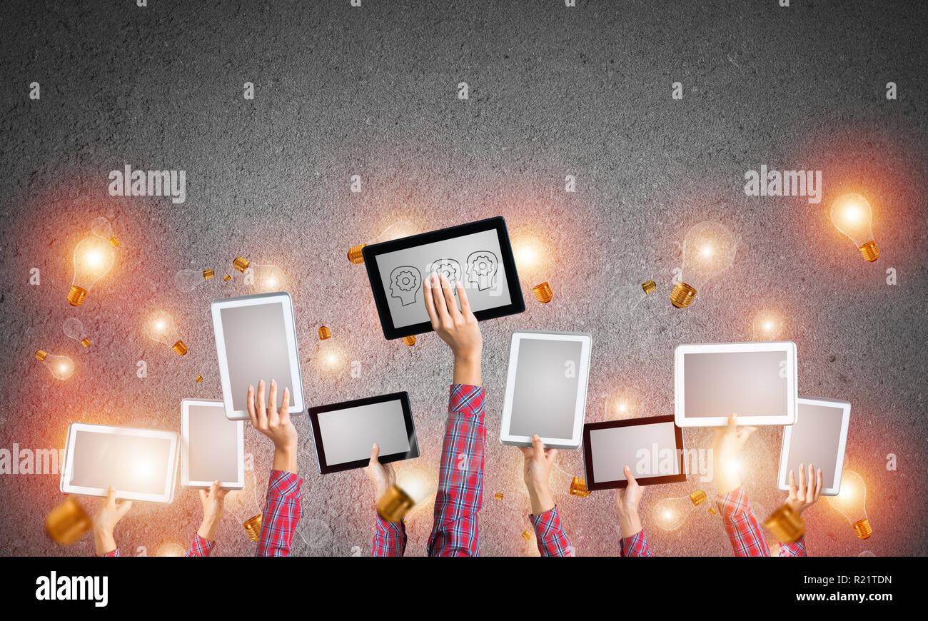 Close of woman hands in line showing tablet pc against concrete wall ...