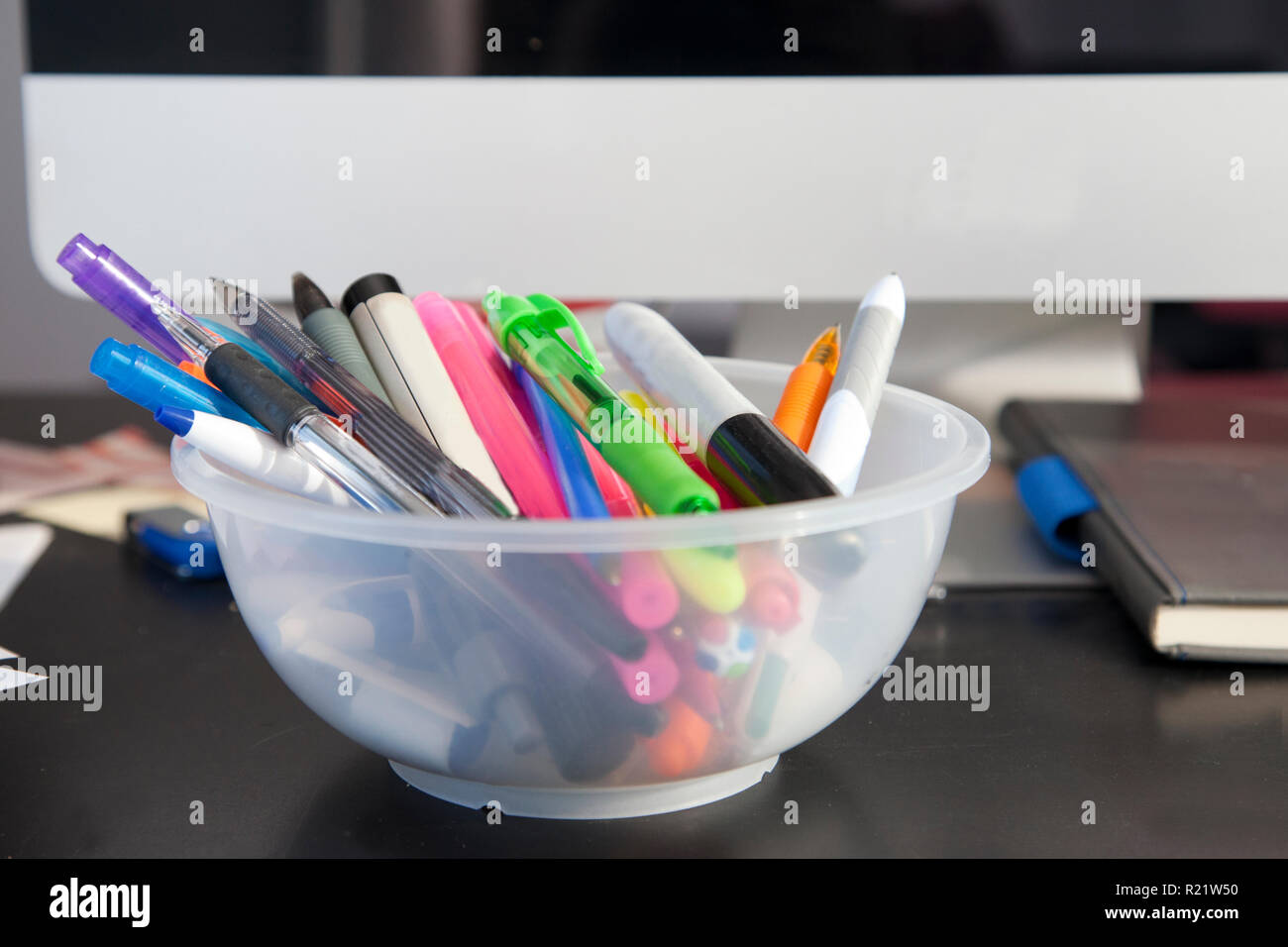 Pens, highlighters, and markers in front of a computer and journal at ...