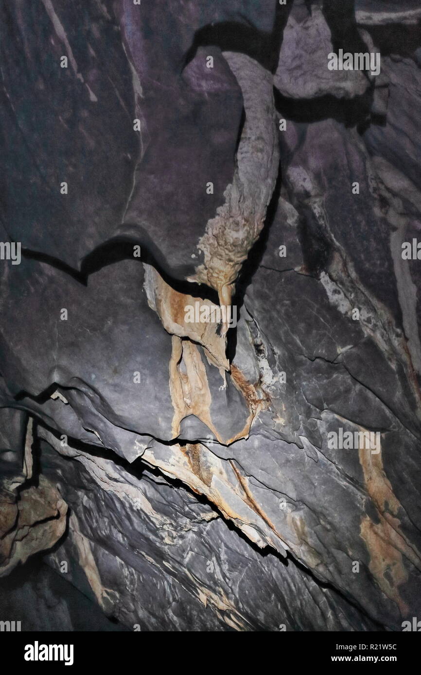 Rock formations of grey limestone with speleogens and reddish ...