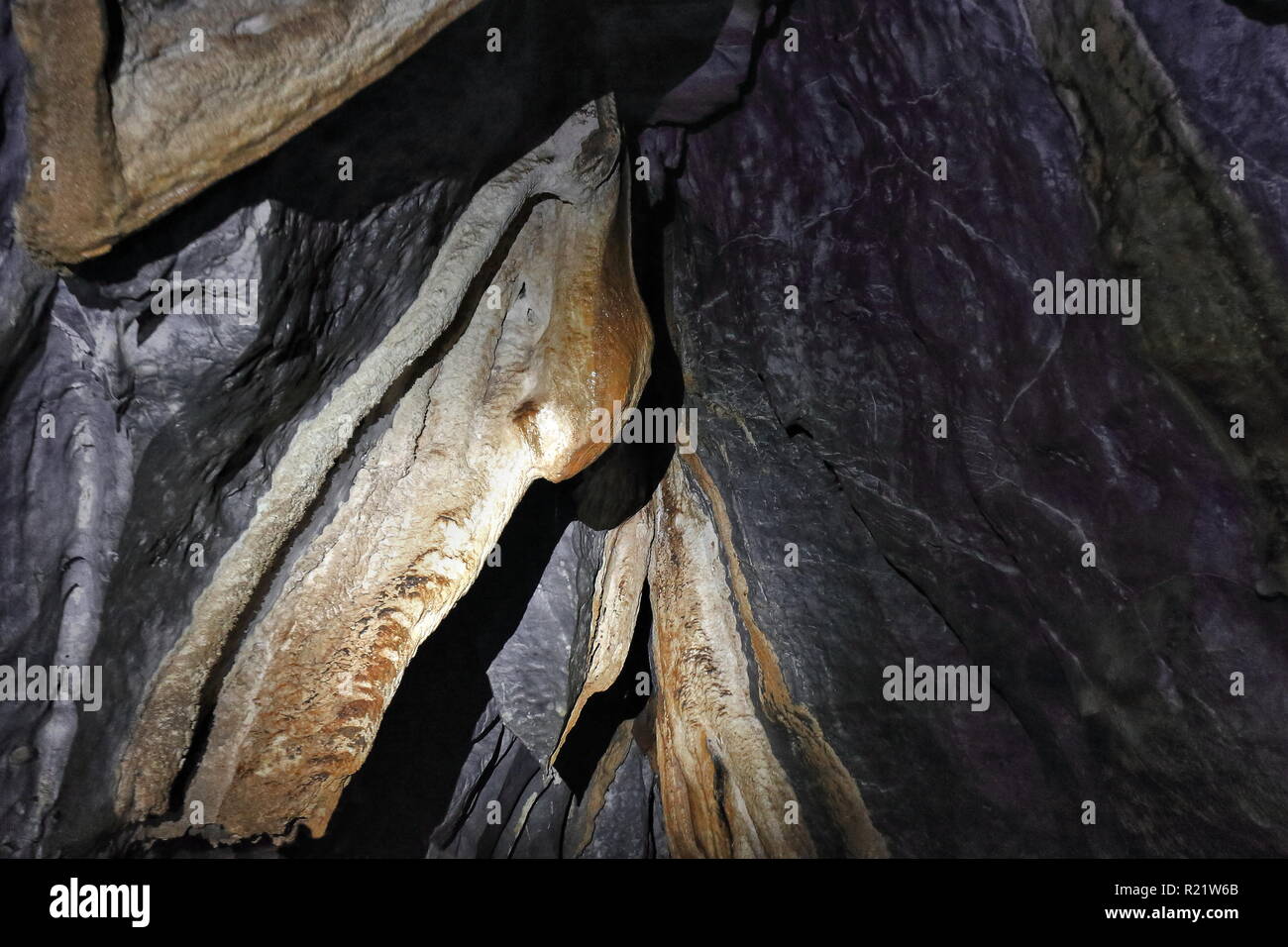 Rock formations of grey limestone with speleogens and reddish ...