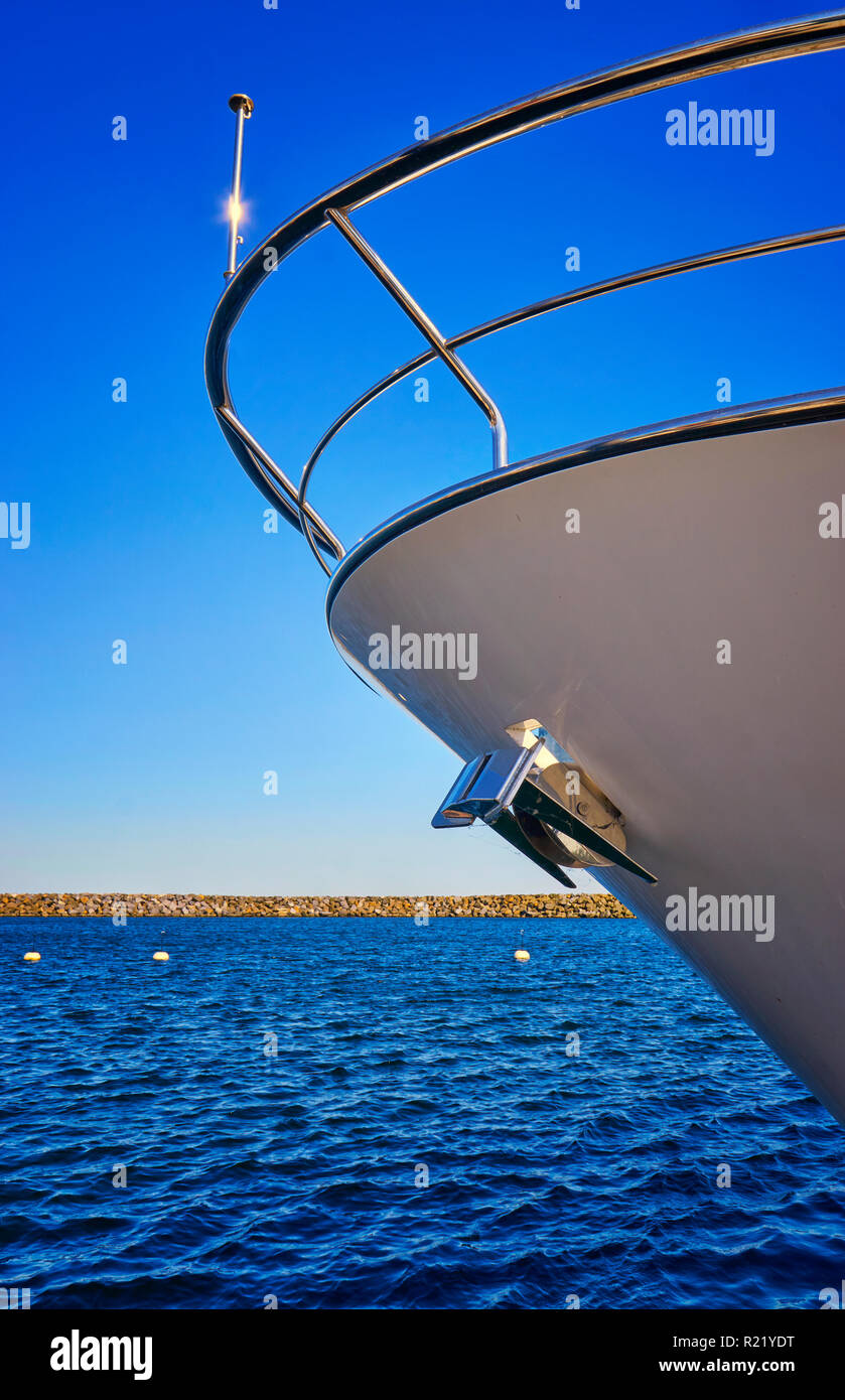 Boat bow from sailboat in blue water with anchor chain and winch detail ...
