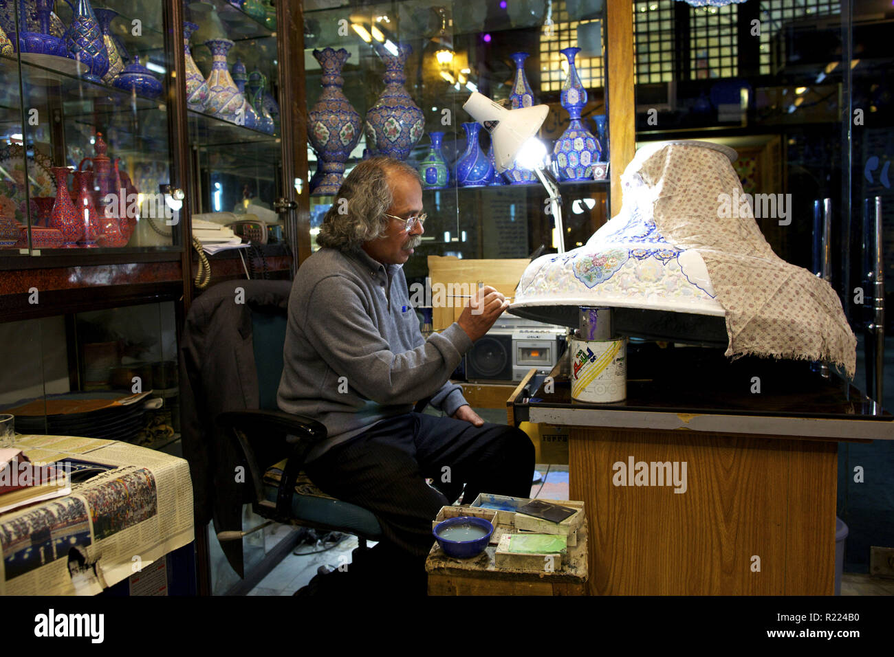 Iran, Isfahan Enameler working in his workshop of the Grand Bazaar ...