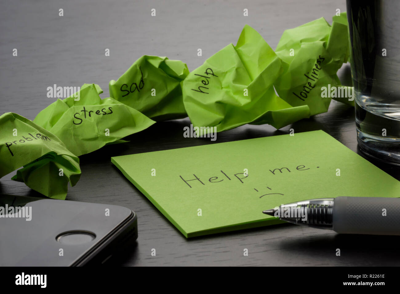 Depression. The phrase "help me" is written on a green sticky note on ...