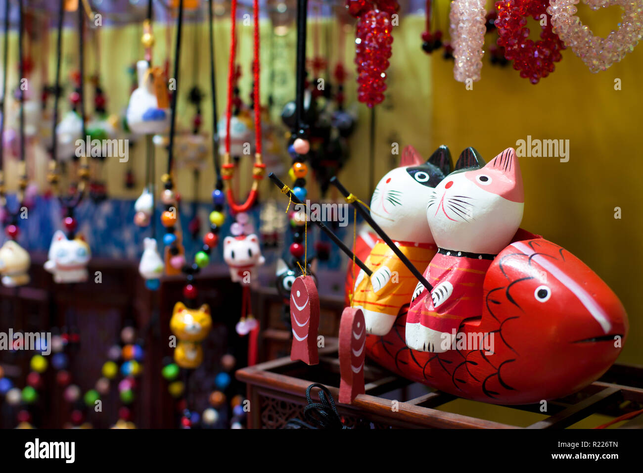 Two wooden toy cats fishing in a chinese souvenir shop Stock Photo - Alamy