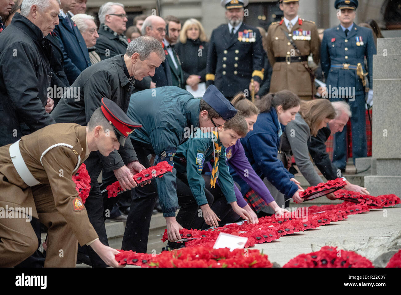 Members of various services and forces are seen laying poppy wreaths ...