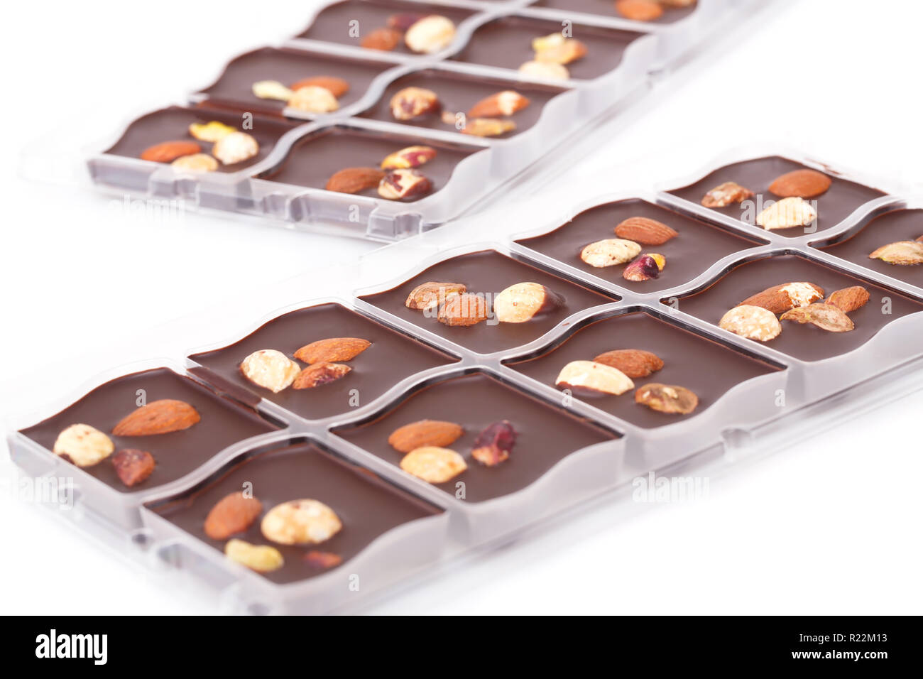 Chocolate with assortment nuts in plastic boxes on white background ...