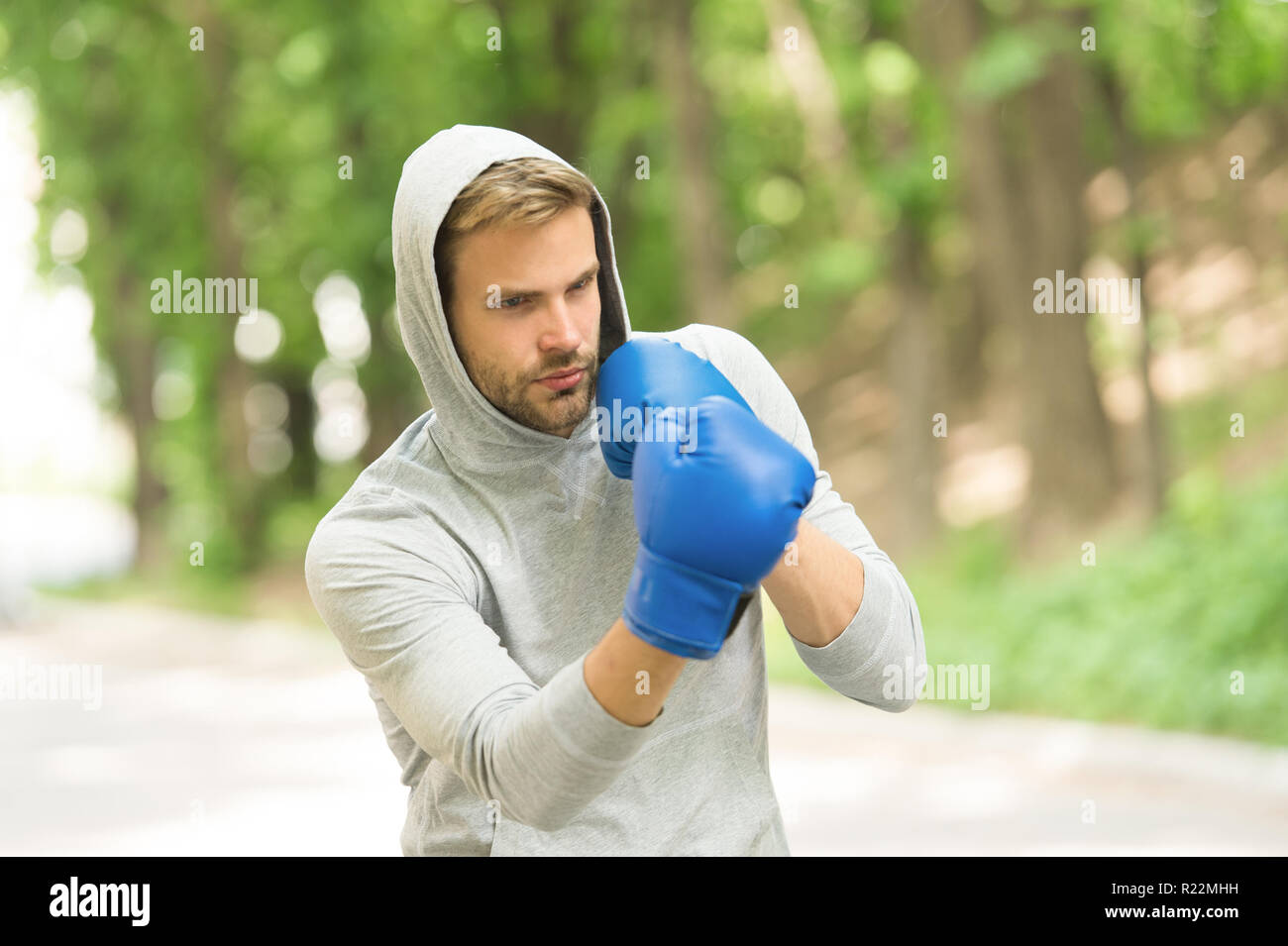 Sharpen his skill. Sportsman concentrated training boxing gloves ...