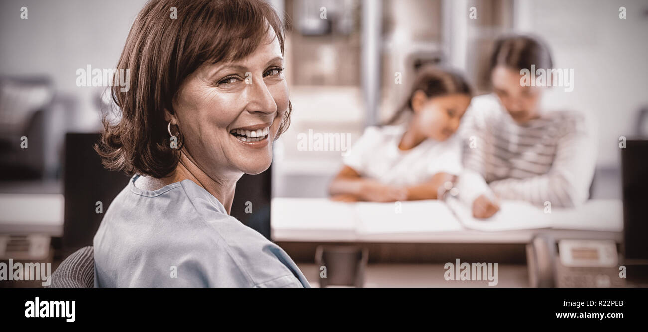 Portrait of smiling nurse sitting at desk Stock Photo - Alamy