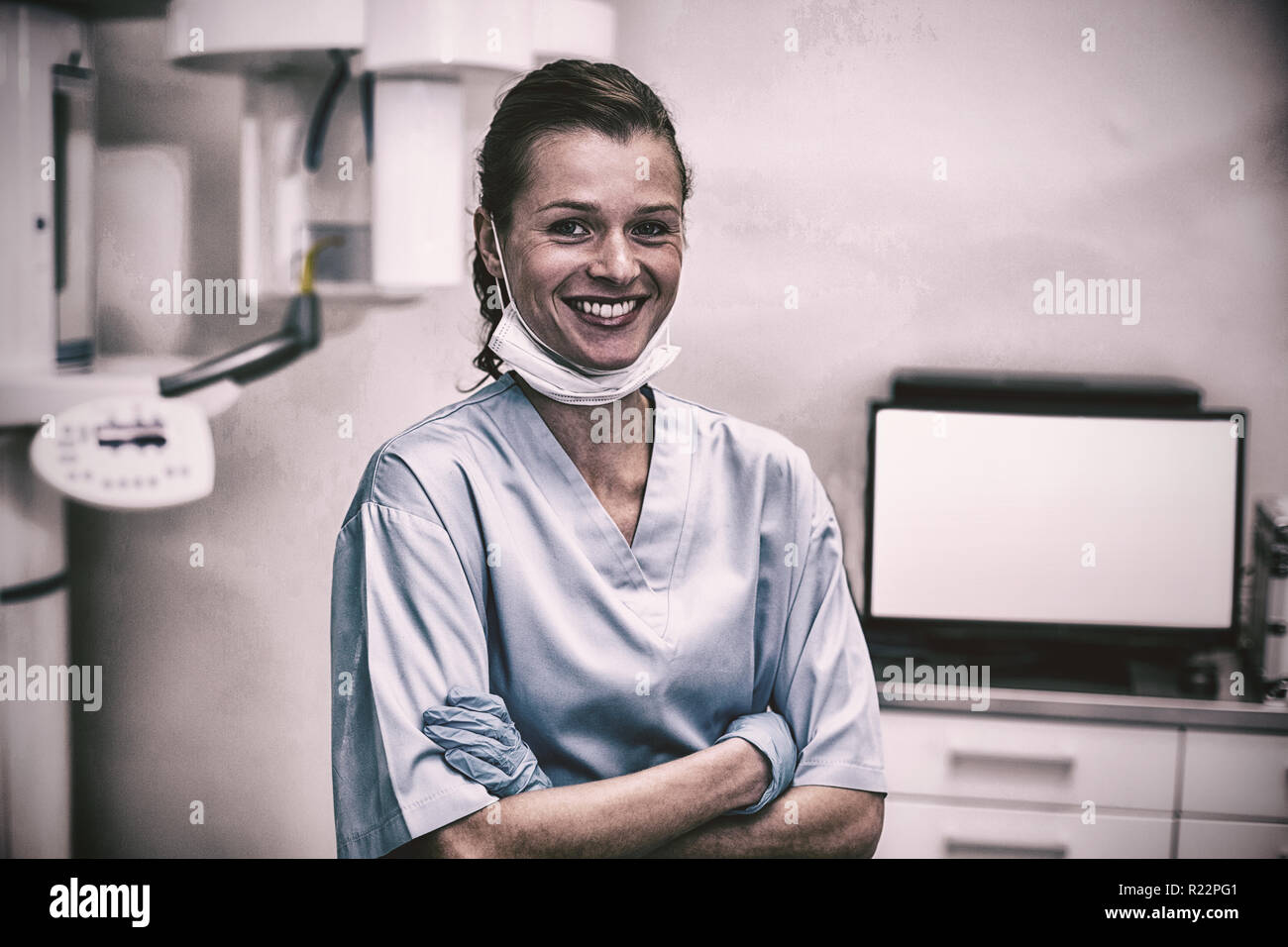 Smiling dental assistant standing with arms crossed Stock Photo - Alamy
