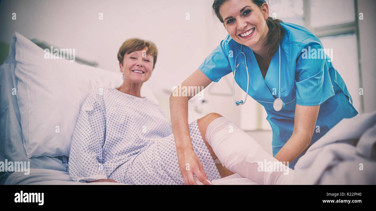 Nurse bandaging leg of patient Stock Photo - Alamy
