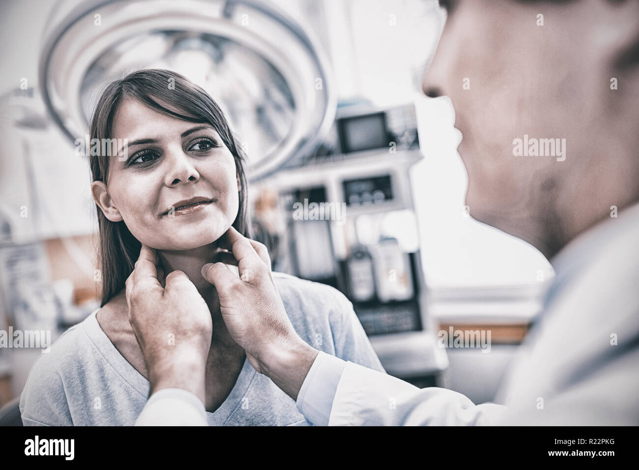 Doctor examining a female patients neck Stock Photo - Alamy